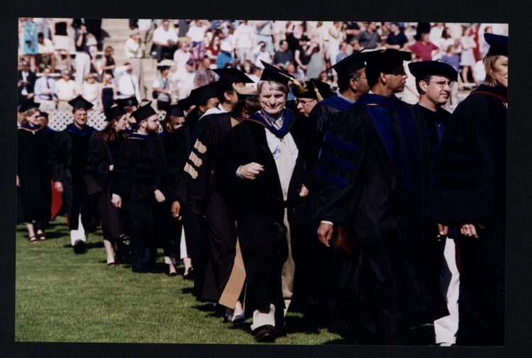 Female graduate smiling, walking with graduates | Lehigh Preserve