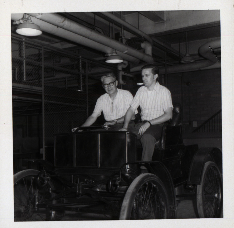 Two men sitting in Packard Automobile inside Packard Laboratory ...