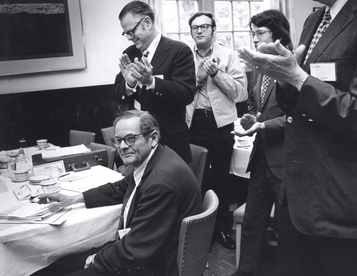 Four men clapping, One sitting down at dinner table | Lehigh Preserve